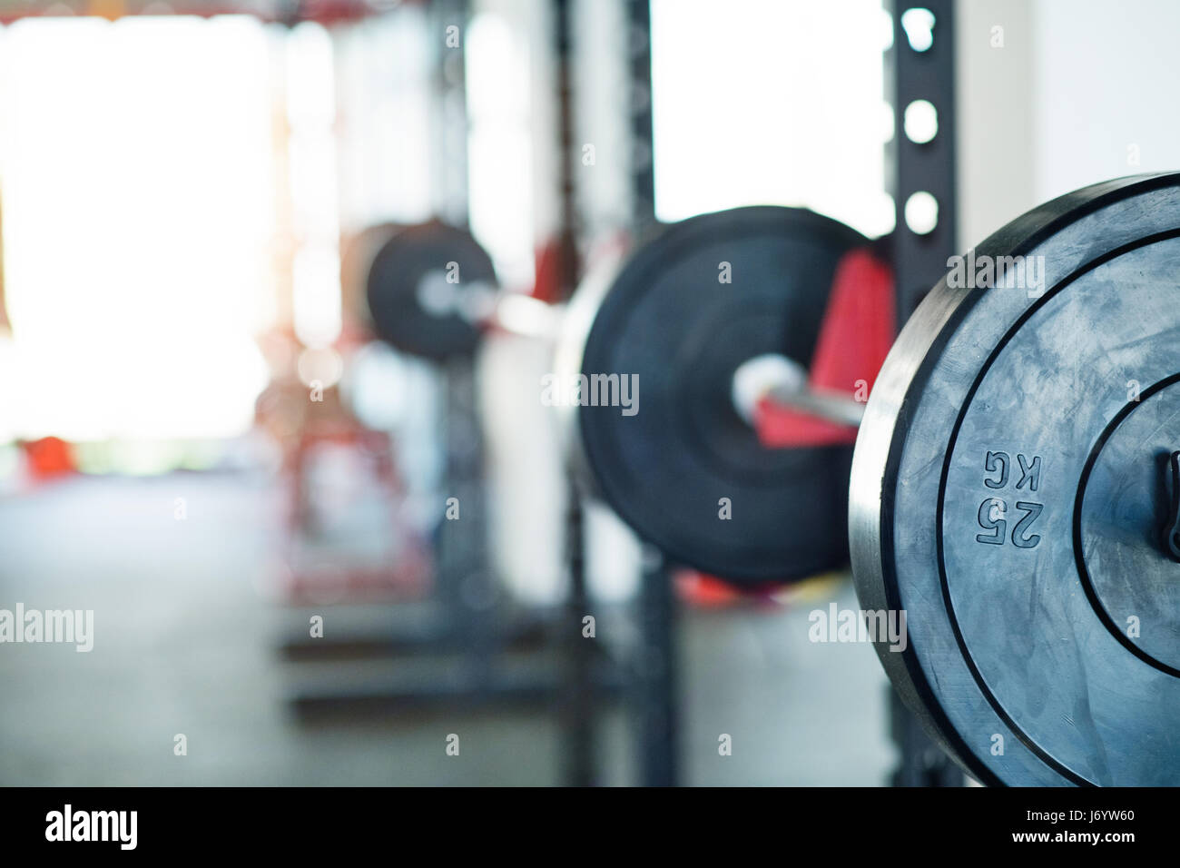 Metal heavy barbell in holder in modern gym Stock Photo - Alamy