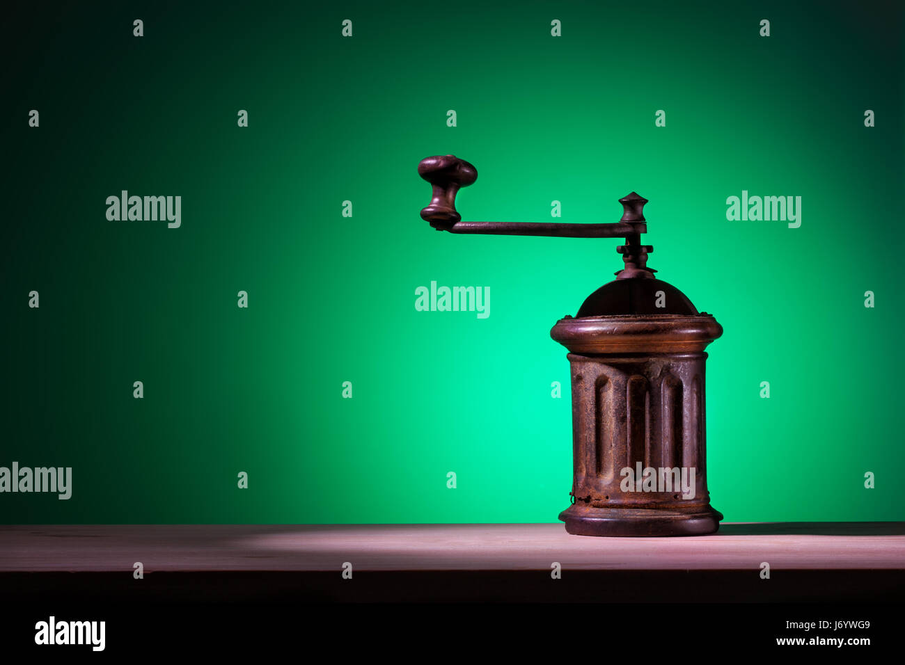 An old rusty coffee grinder on a green background Stock Photo - Alamy