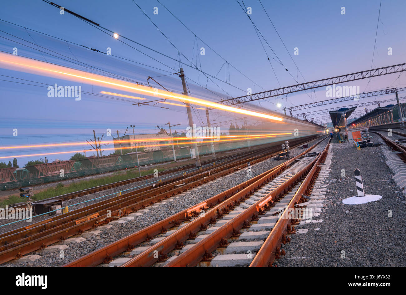High speed passenger train on railroad track in motion at night ...