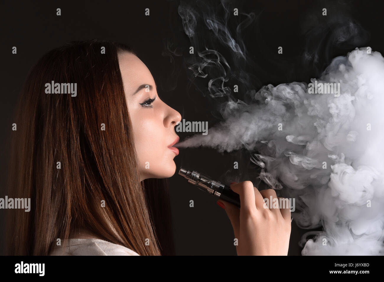 The face of vaping young woman at black studio Stock Photo - Alamy