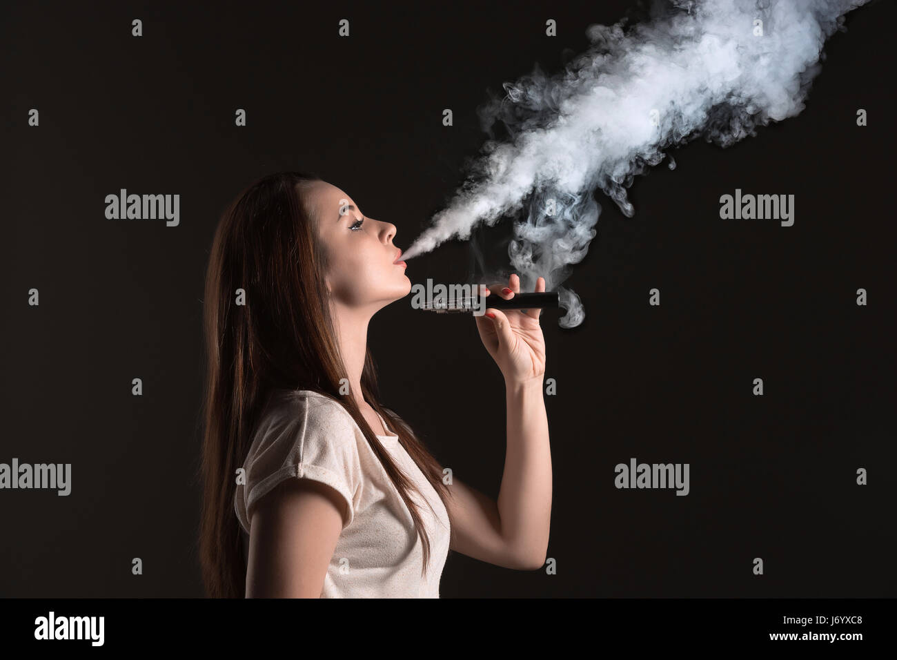 The face of vaping young woman at black studio Stock Photo - Alamy