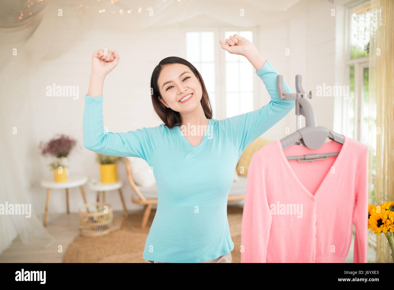 Happy young asian woman finish steaming clothes in room Stock Photo - Alamy