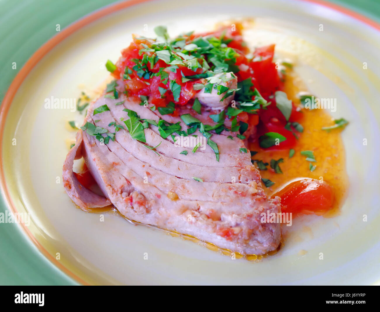 Fillet of tuna cooked in pan with tomato, oil and parsley. Ready to eat ...