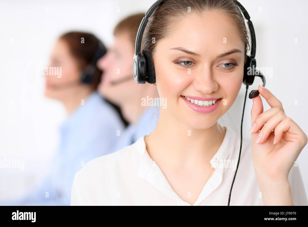 Call center operators. Young beautiful business woman in headset. Male call operator in headset ...