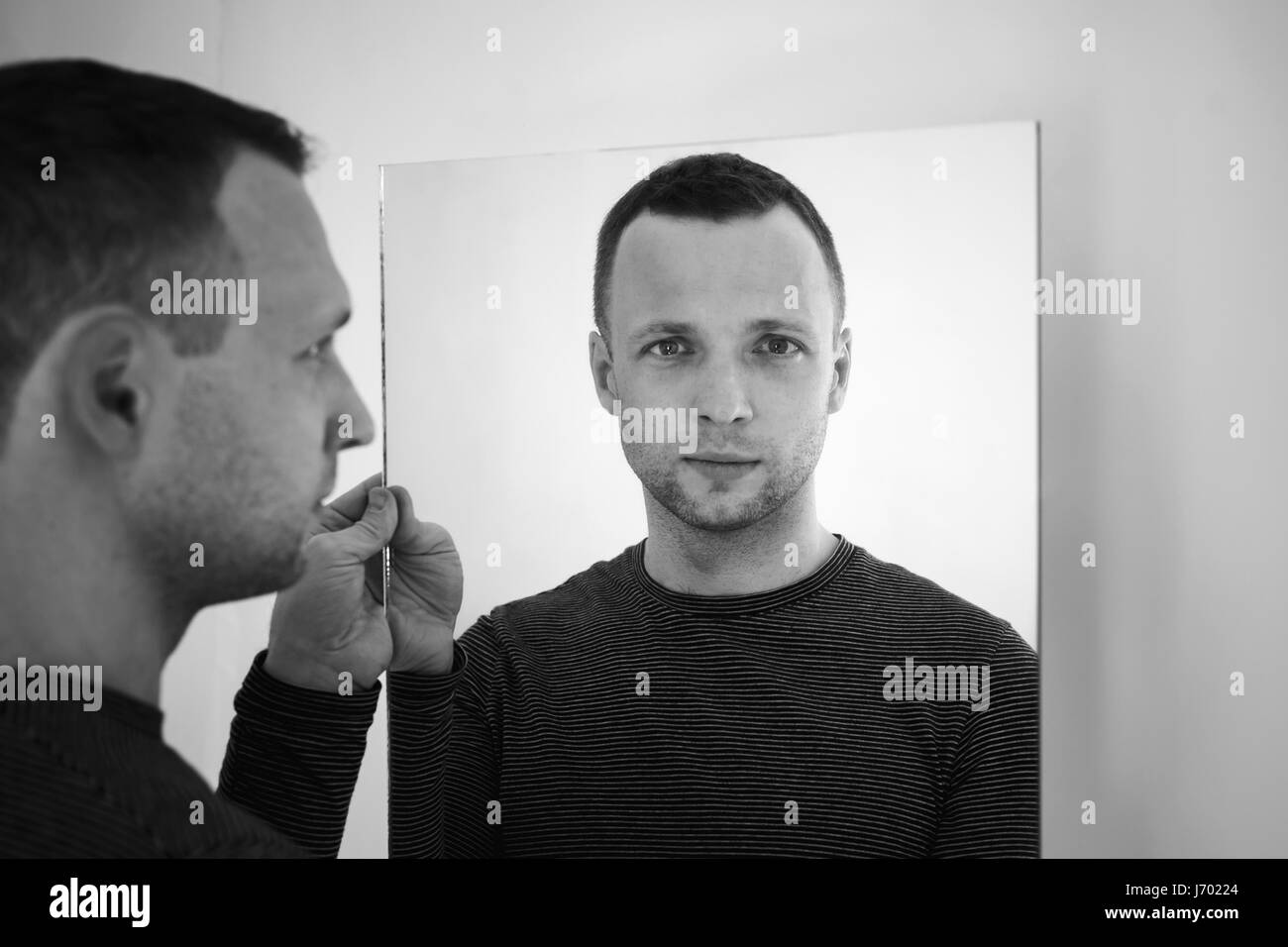 Black and white portrait of young adult European man standing near ...