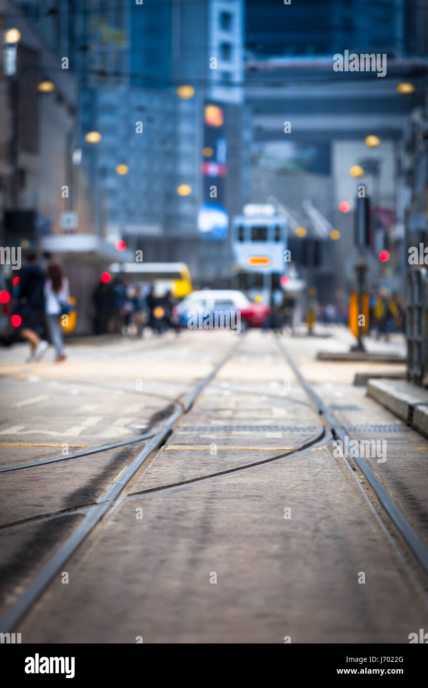 Streetcar tracks toward blurred urban traffic background with tram, car ...