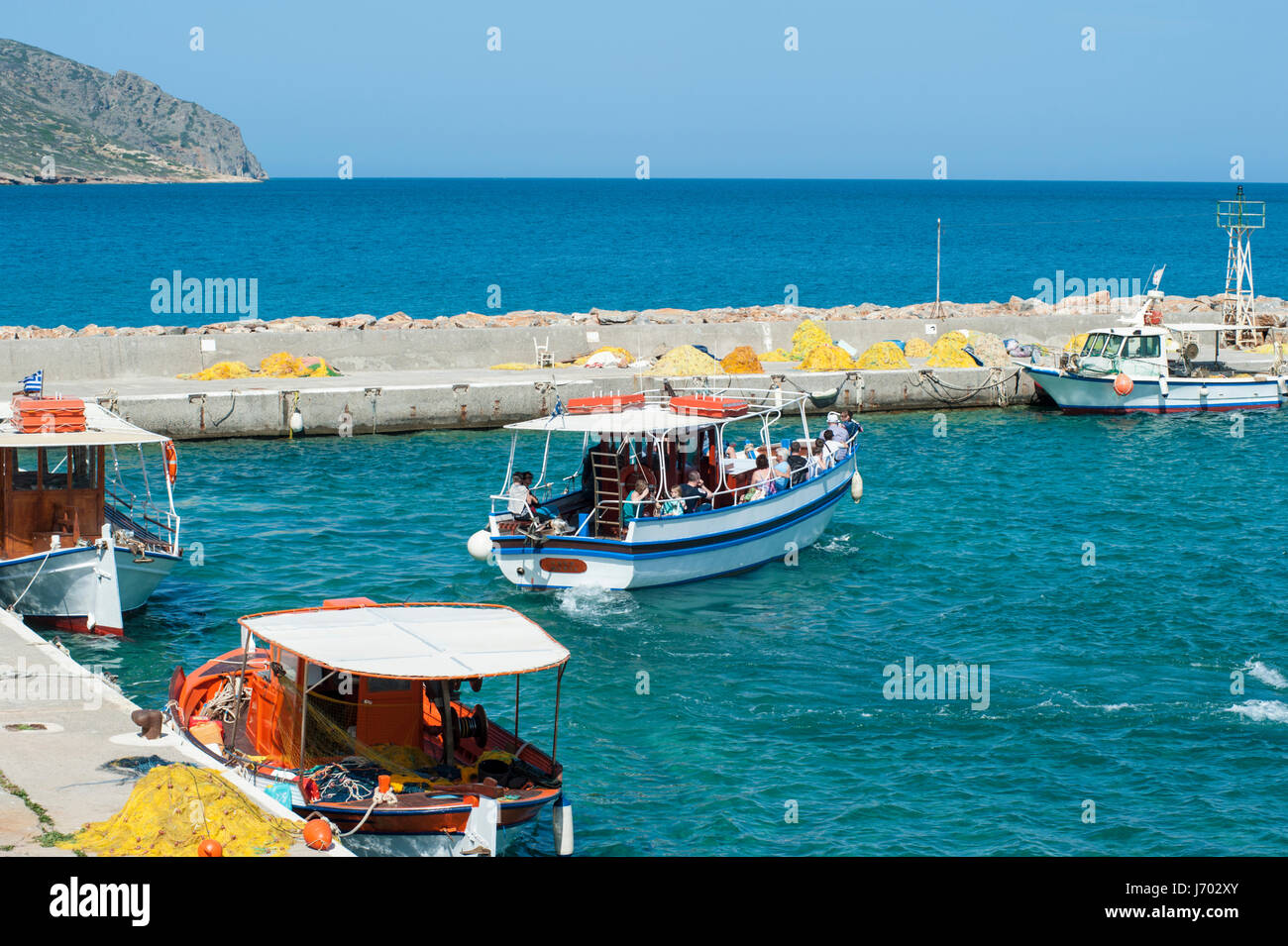 Boats with tourists leaving the jetty in Plaka, a small village on the ...
