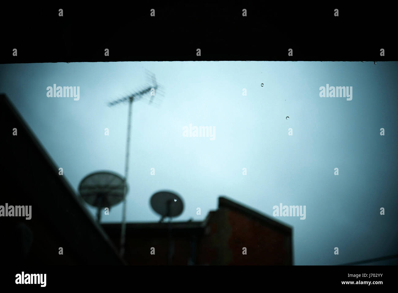 Two raindrops falling from lip of garden umbrella on stormy day Stock ...