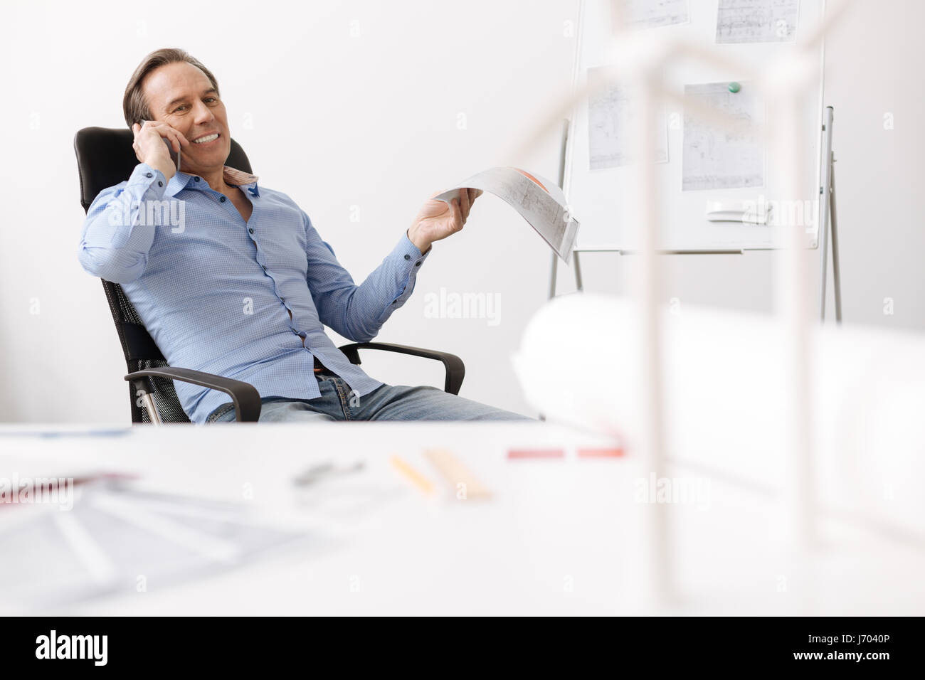 Positive engineer sitting in the office Stock Photo - Alamy