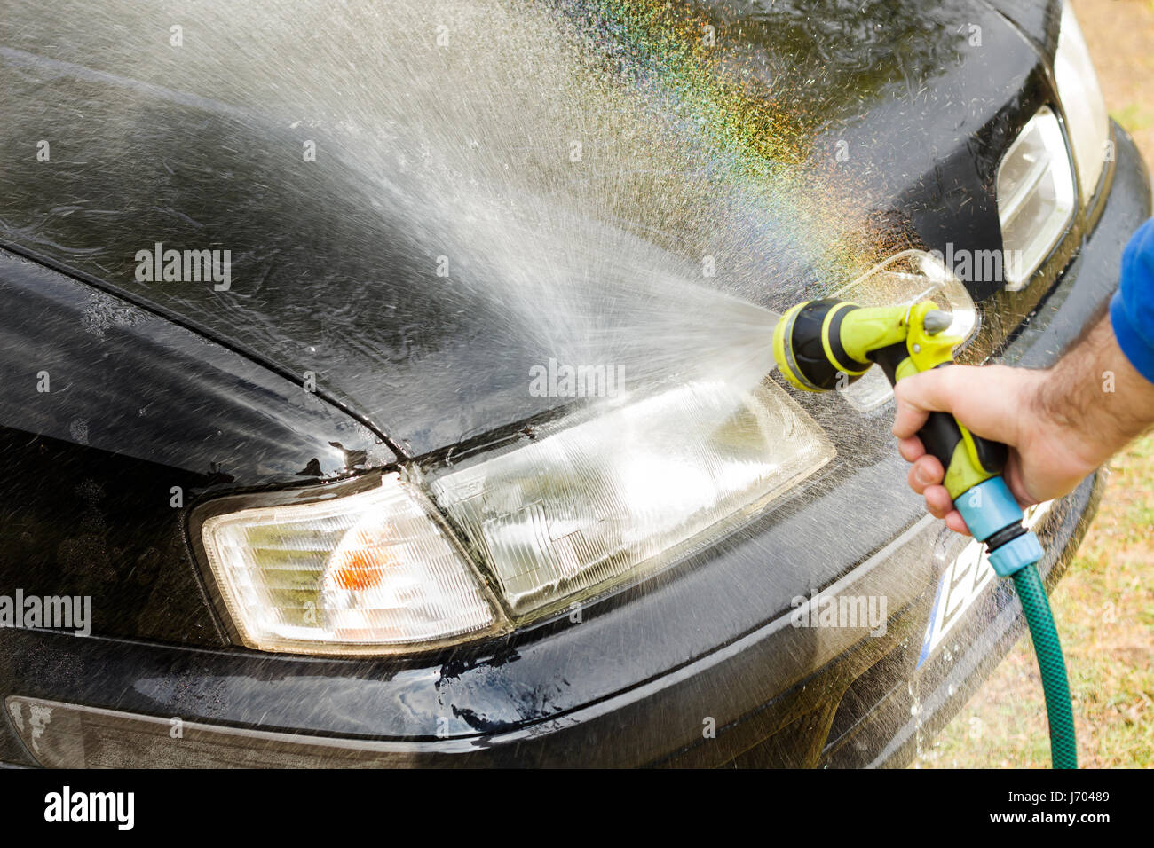 Flushing the car body with water from a garden hose. Washing the car ...