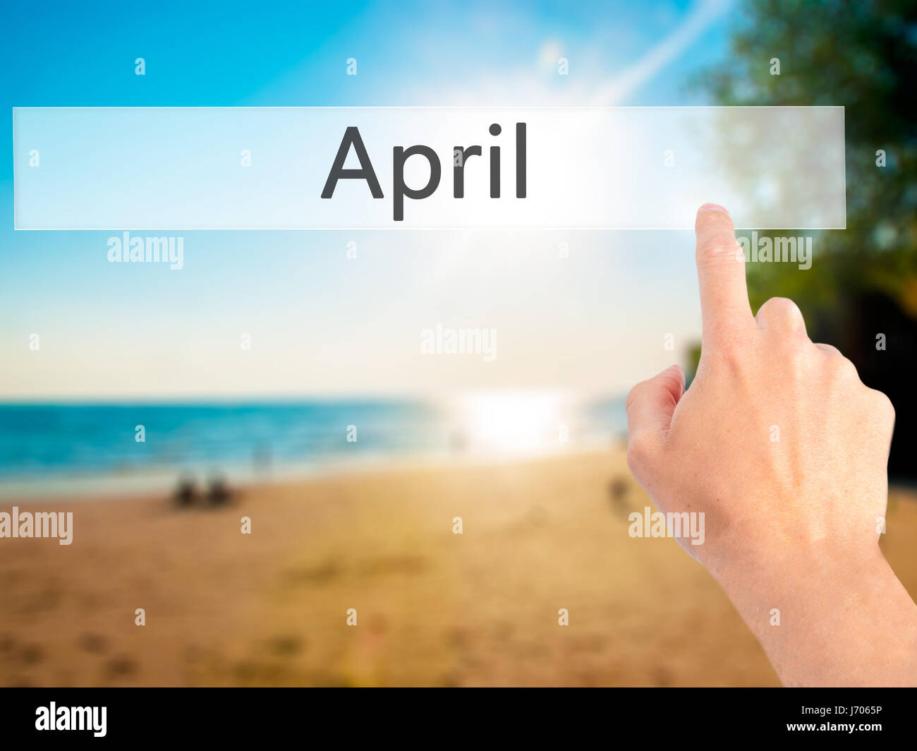 April - Hand pressing a button on blurred background concept . Business ...