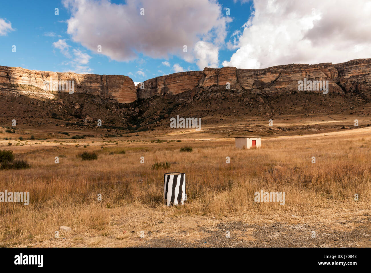 Golden cold dry winter landscape and rocky mountain against blue cloudy ...
