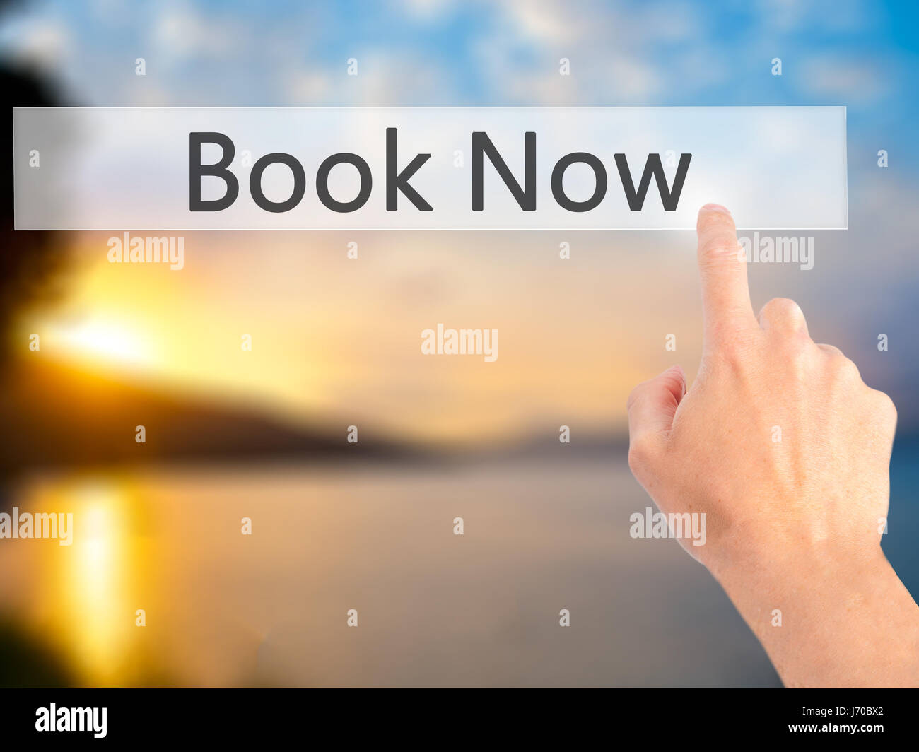 Book Now - Hand pressing a button on blurred background concept ...