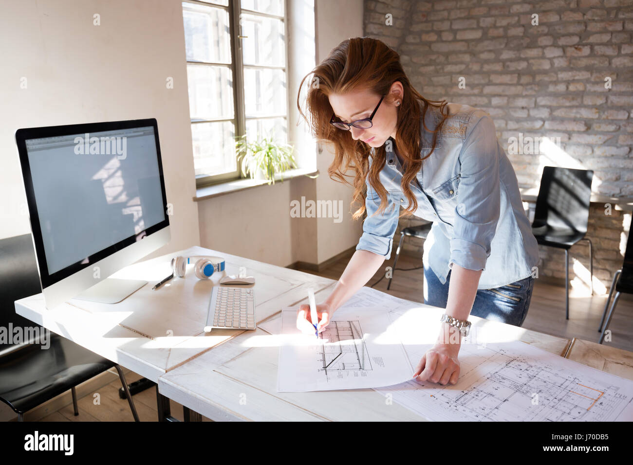 Female designer in office working on architects project Stock Photo - Alamy