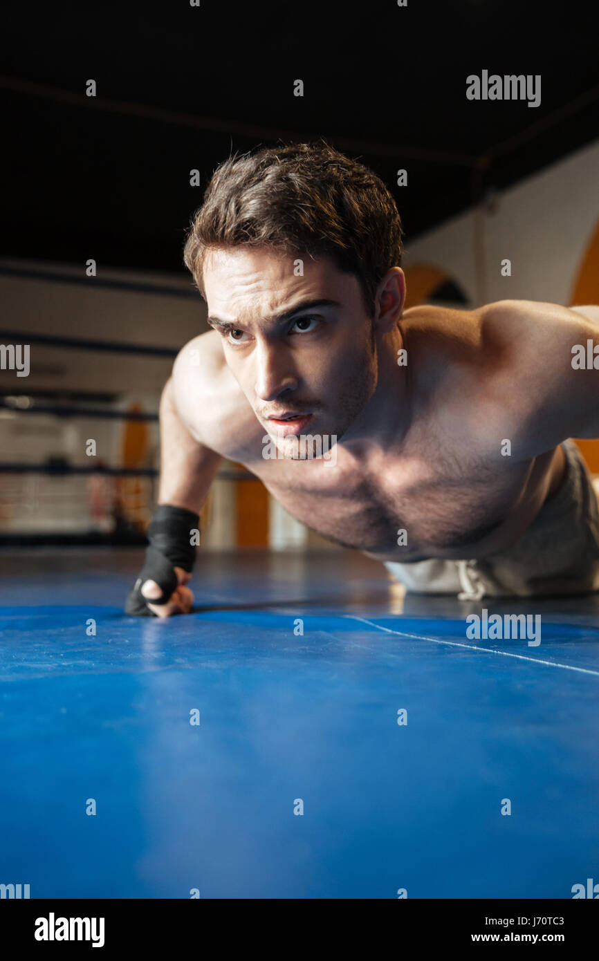 Vertical image of a boxer doing push ups in boxing ring Stock Photo - Alamy