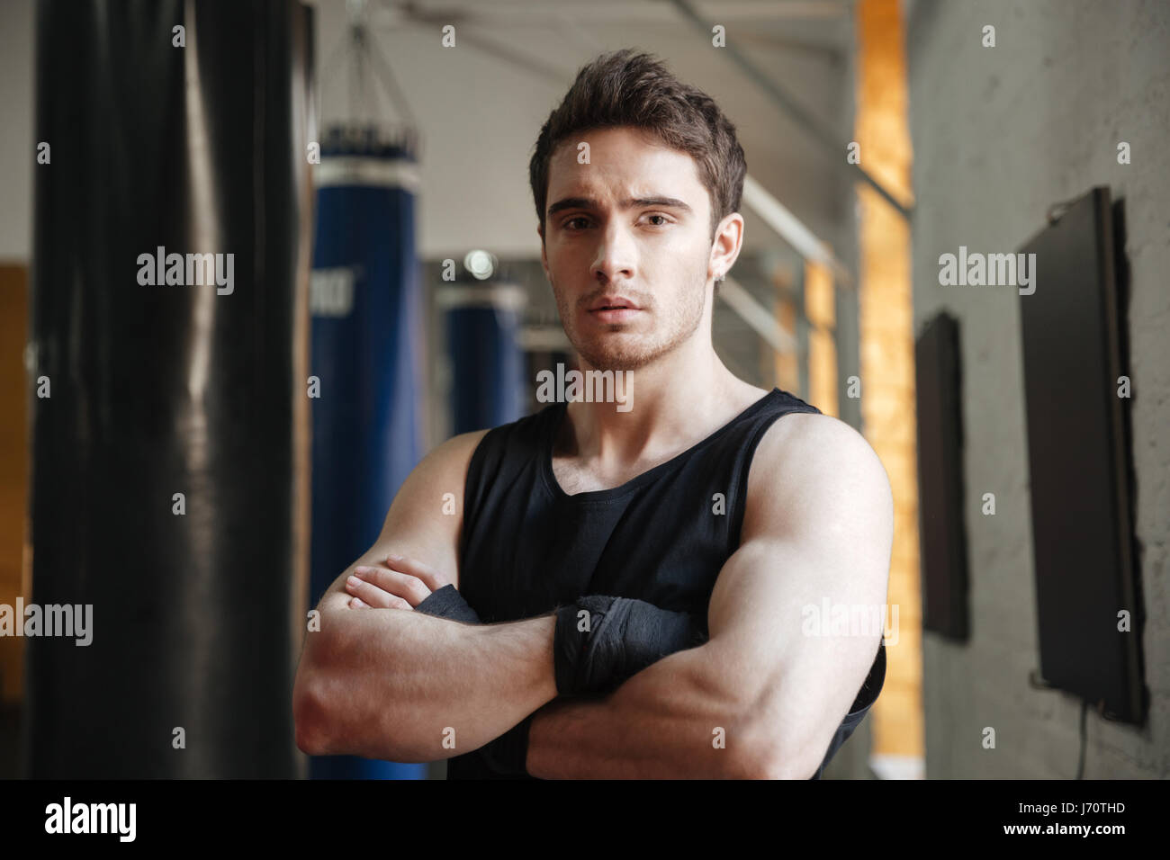 Serious boxer standing with crossed arms in gym Stock Photo - Alamy