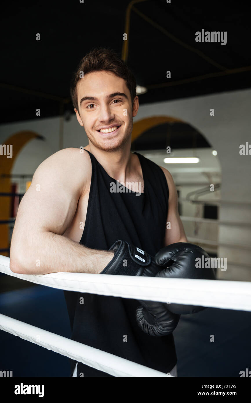 Cheerful boxer in black boxing gloves looking at camera in gym Stock ...