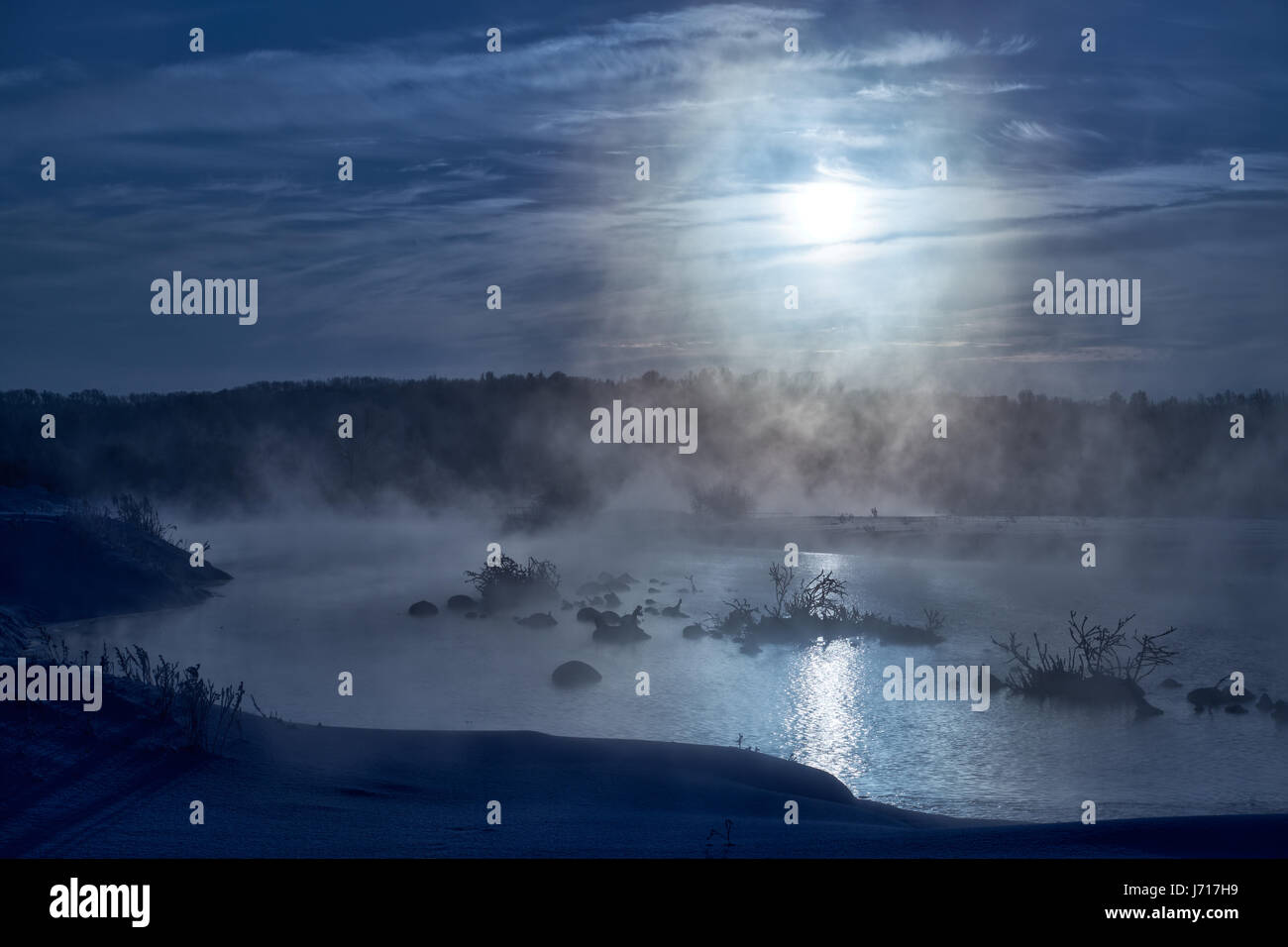 Snags in the river water in winter Moon night. Blue fog backlit by ...