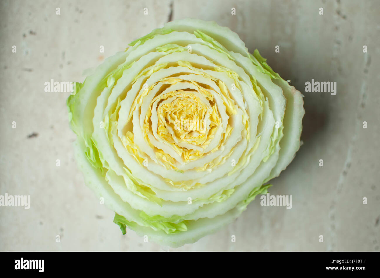 Cut Chinese cabbage stalk on a wooden table. Top view, soft selective ...