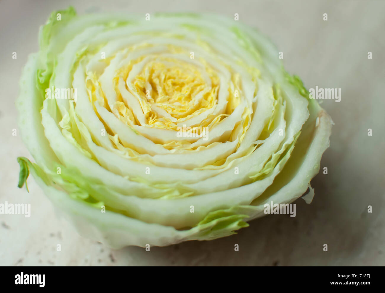 Cut Chinese cabbage stalk on a wooden table. Top view, soft selective ...