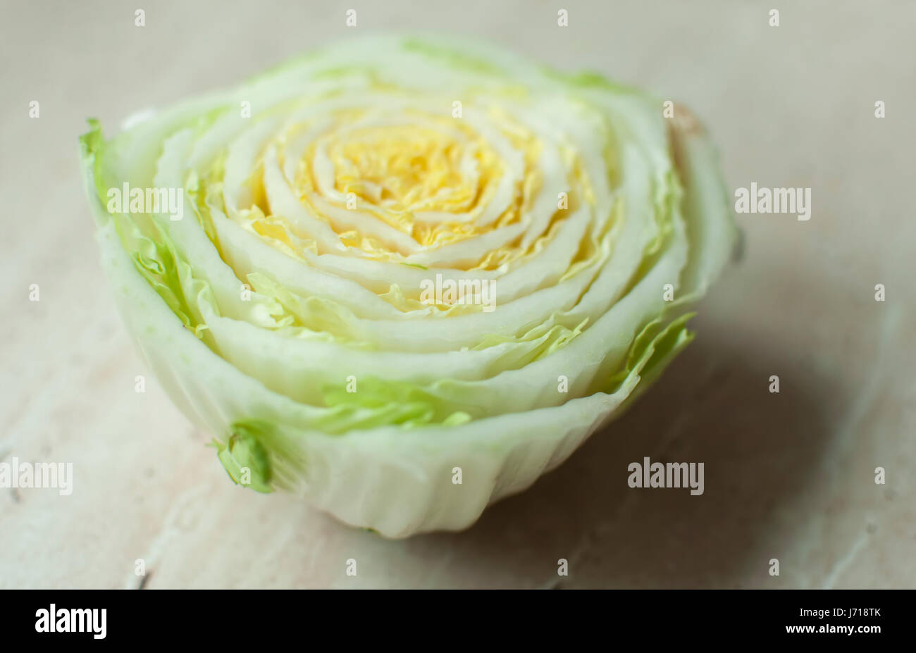 Cut Chinese cabbage stalk on a wooden table. Top view, soft selective ...