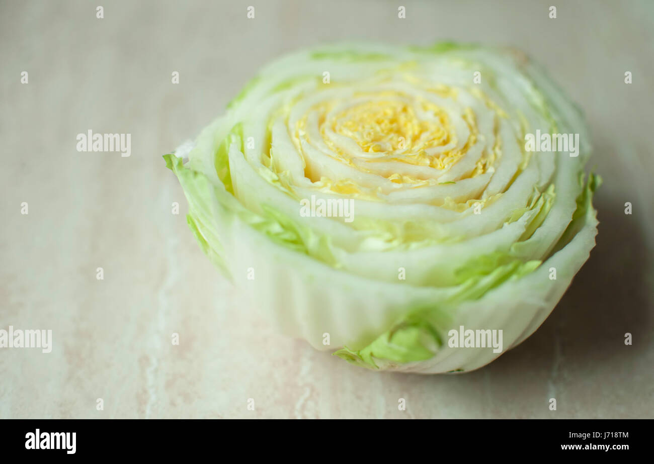 Cut Chinese cabbage stalk on a wooden table. Top view, soft selective ...