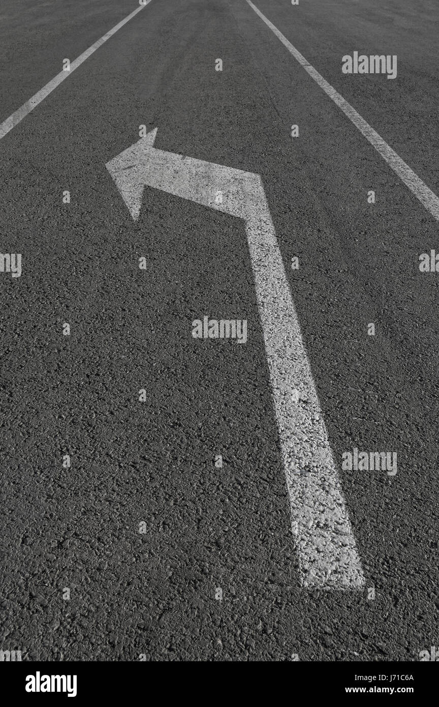 Turn left white arrow sign on asphalt road Stock Photo - Alamy