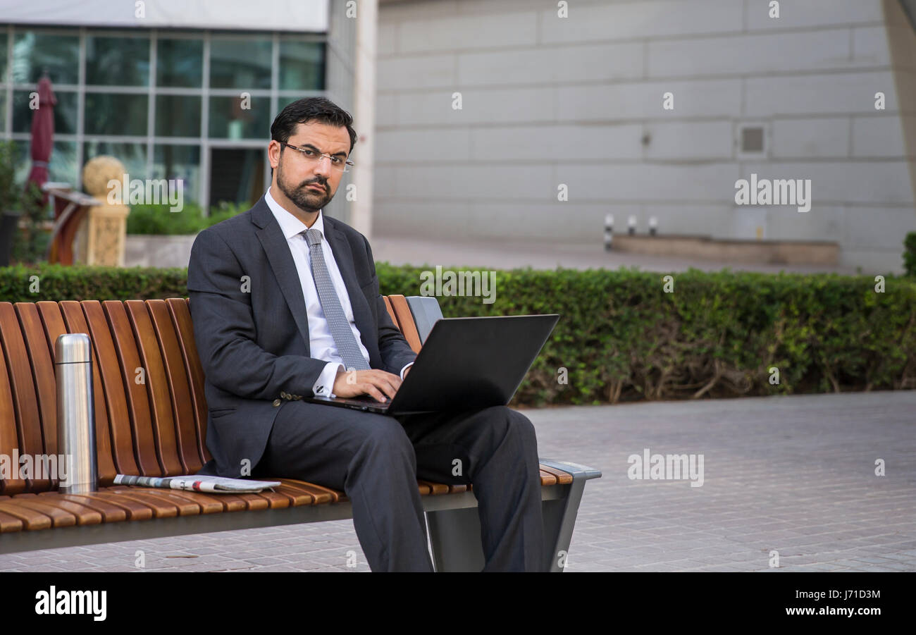 Businessman with a computer outdoors Stock Photo - Alamy