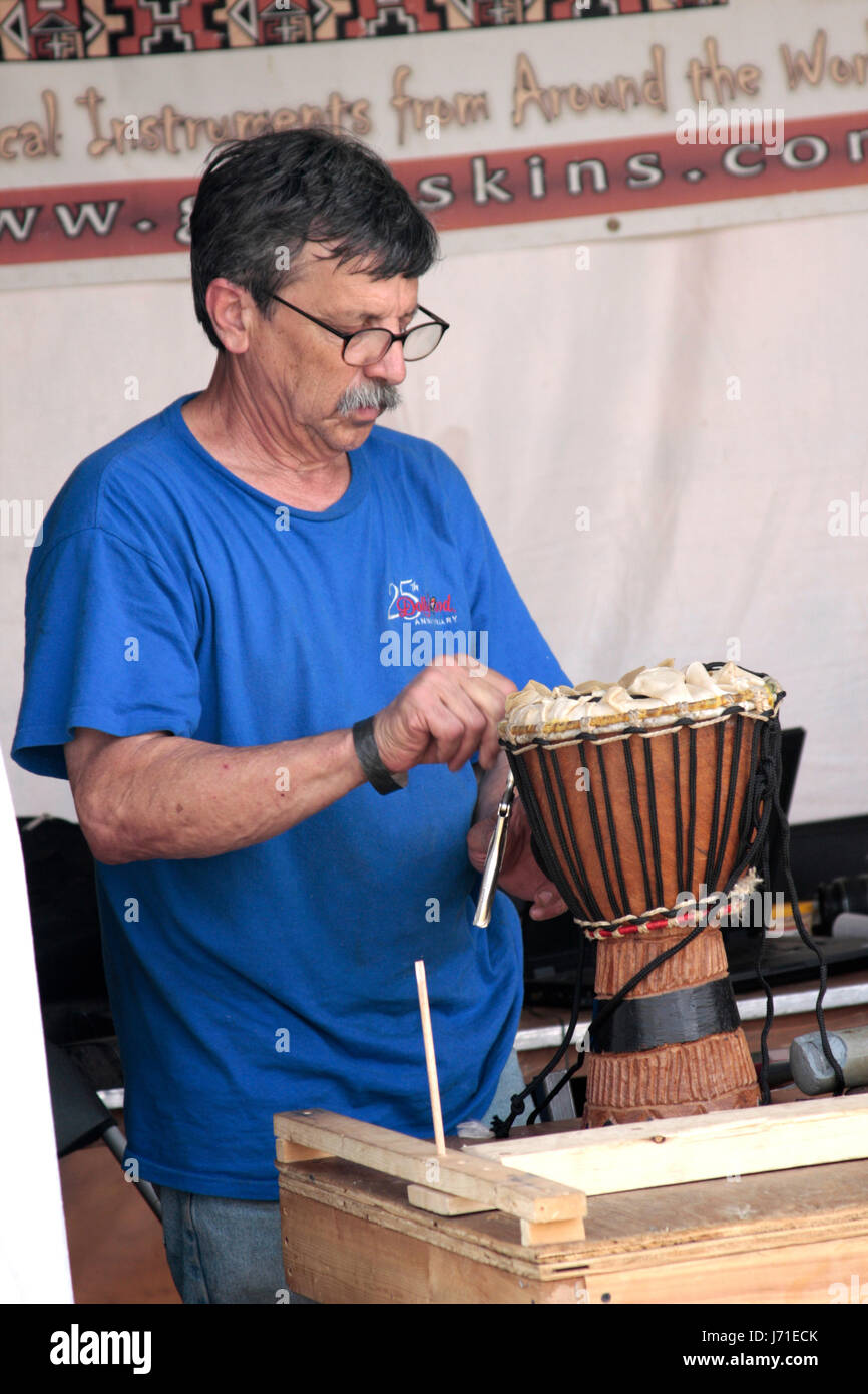 DrumStrong - Man putting new head on drum Stock Photo - Alamy
