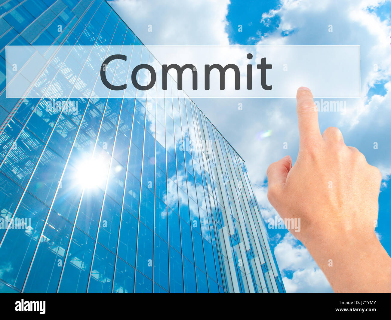 Commit - Hand pressing a button on blurred background concept ...