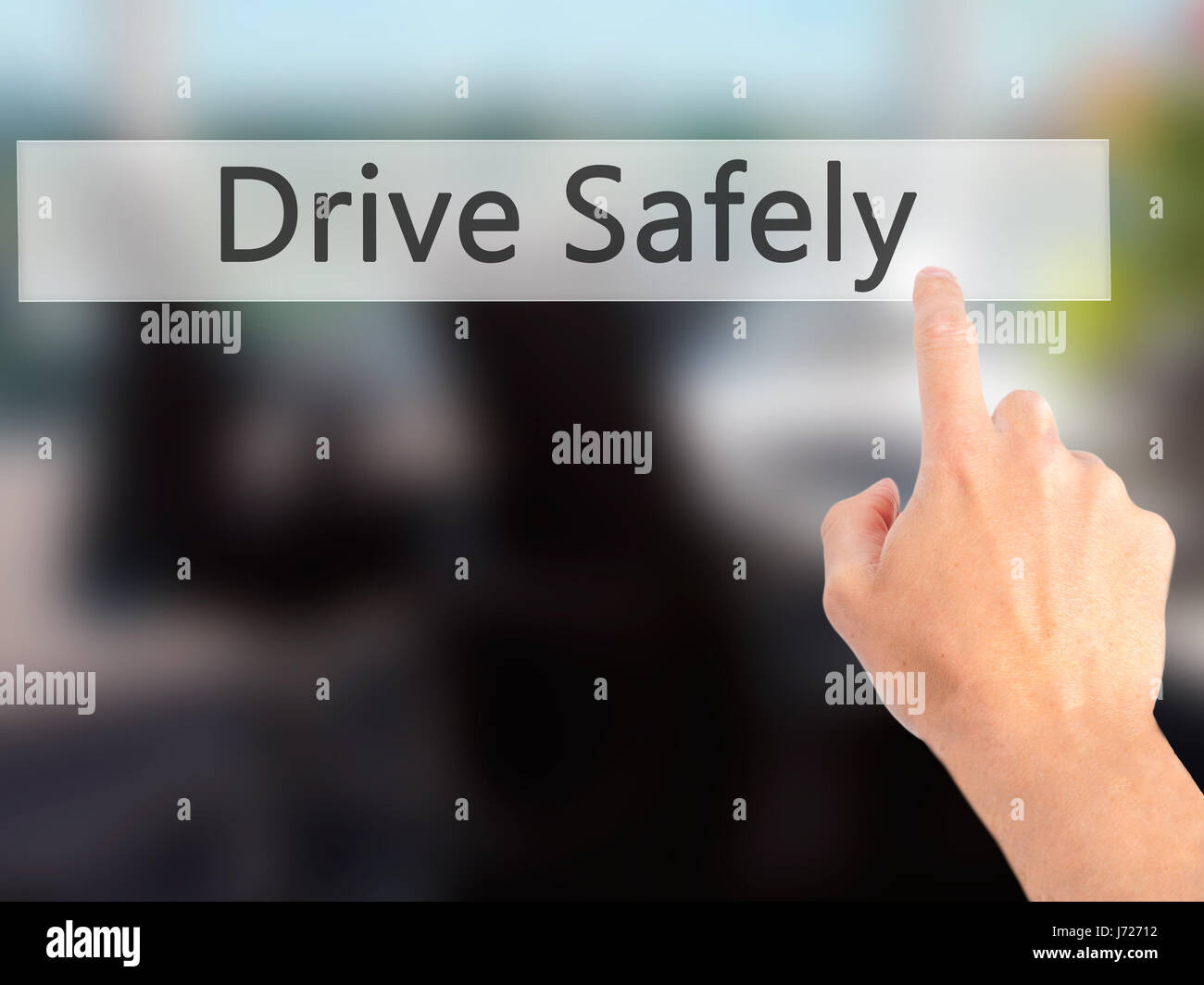 Drive Safely - Hand pressing a button on blurred background concept ...