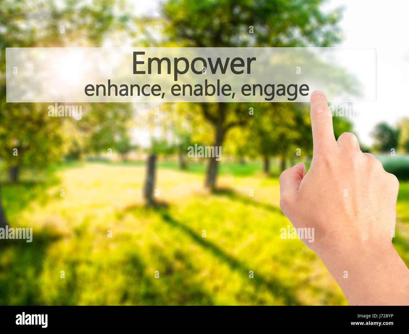 Empower enhance, enable, engage - Hand pressing a button on blurred ...