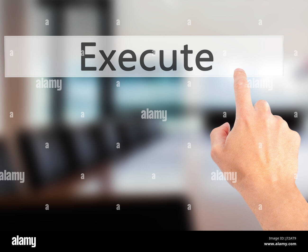 Execute - Hand pressing a button on blurred background concept ...