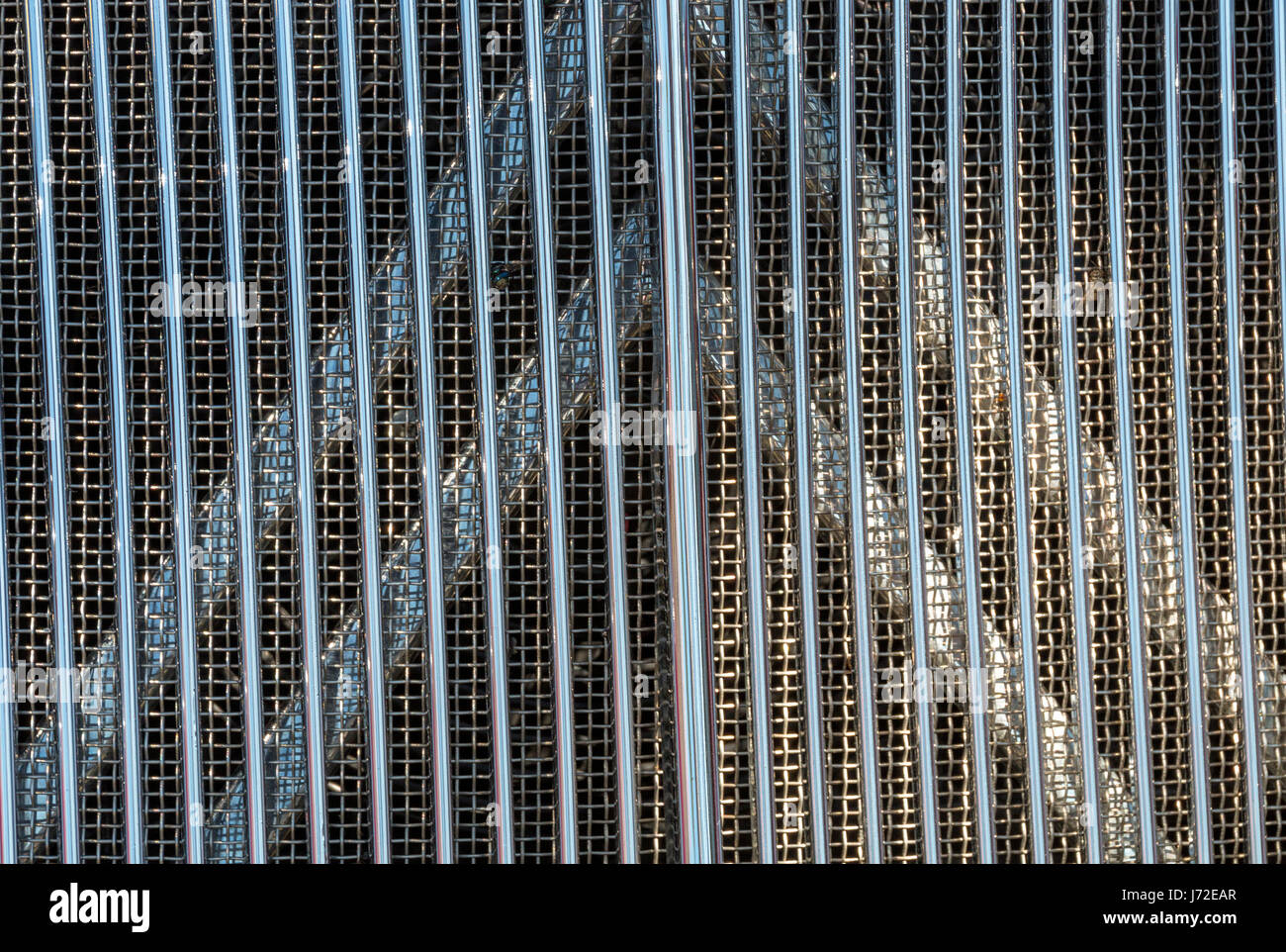 Close up of dark reflective metal square grid patterns and textures ...