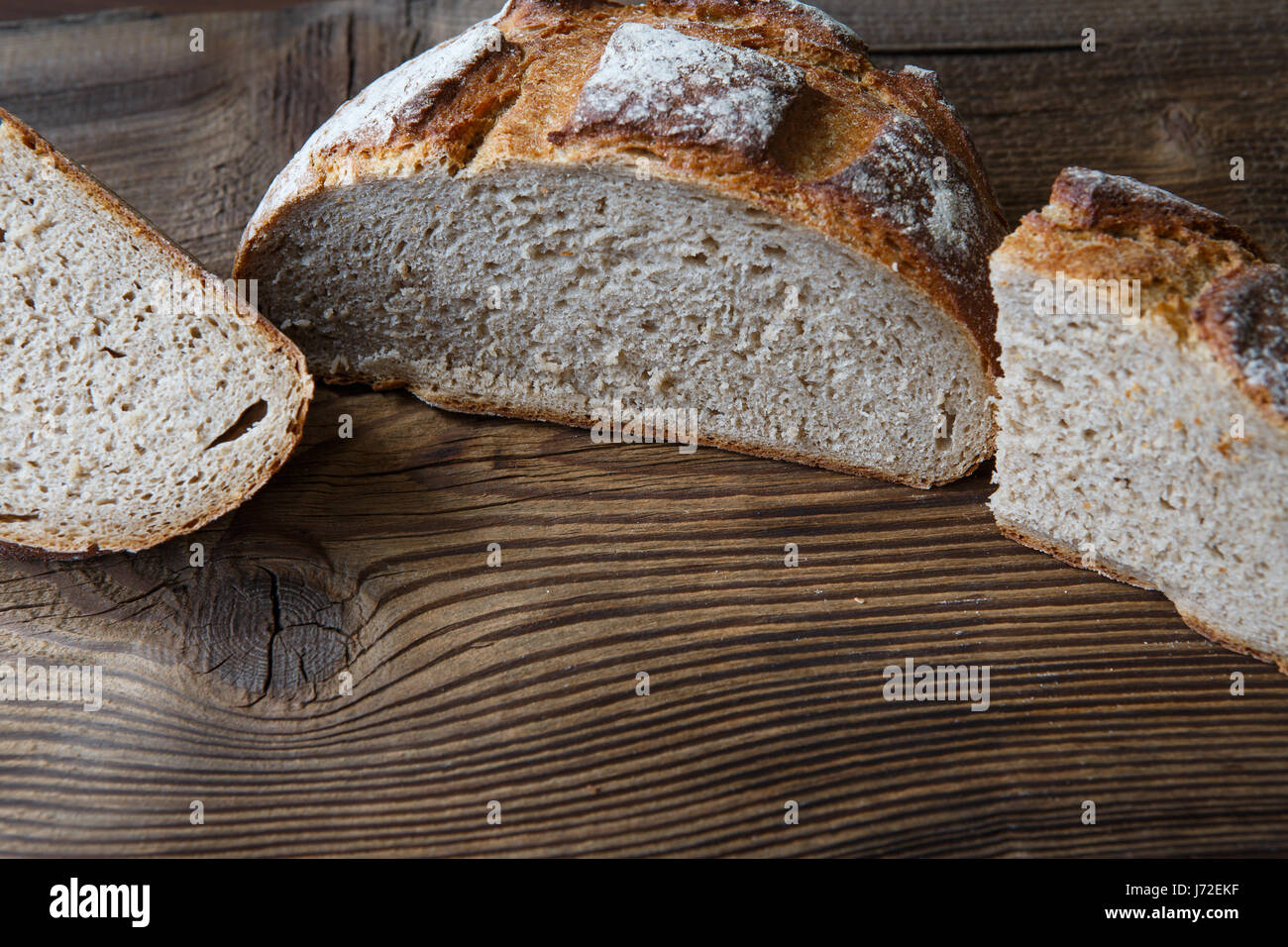 A freshly baked rustic, loaf of bread on an old wooden table Stock ...