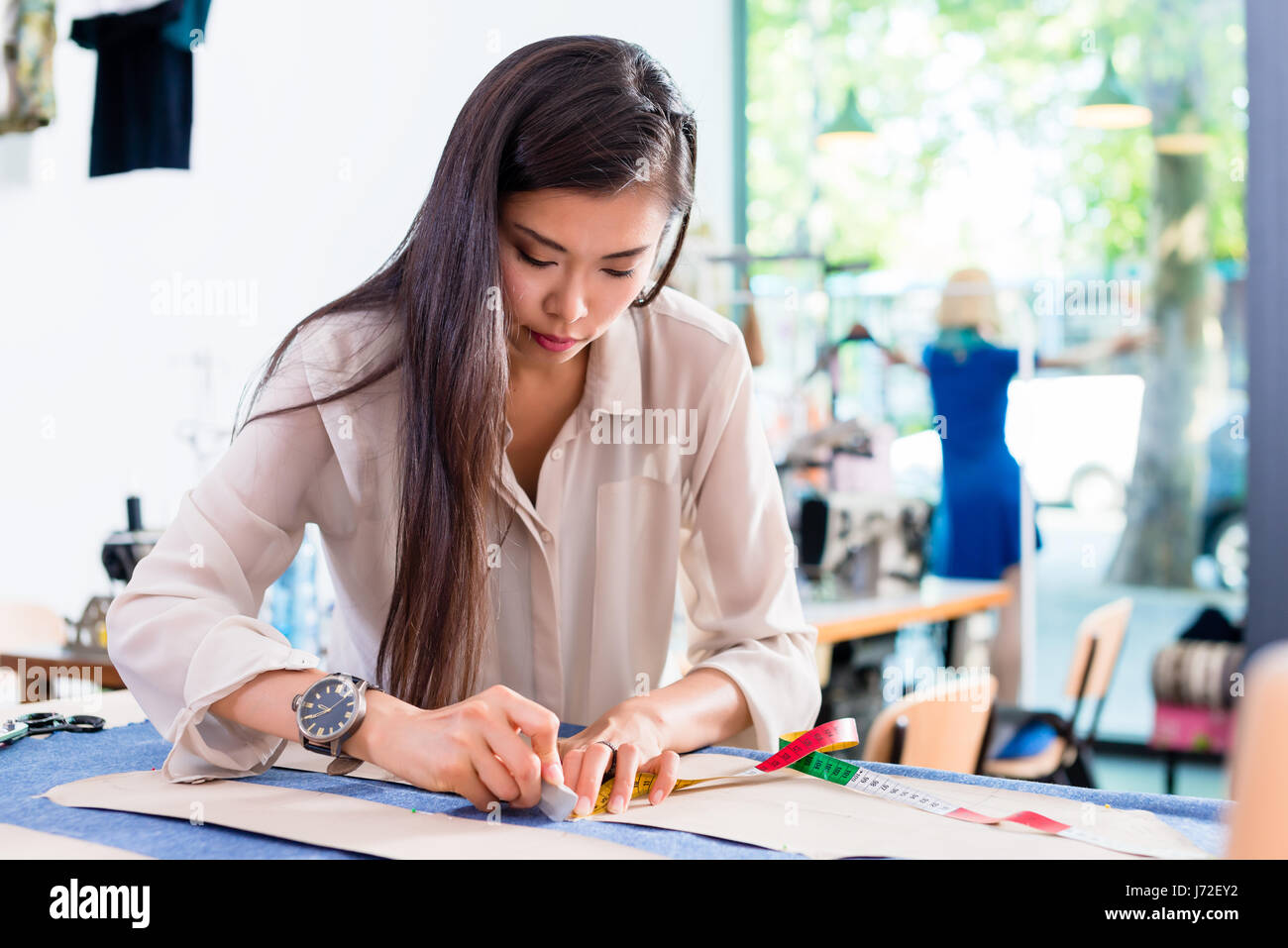 Asian fashion designer woman drafts cut pattern Stock Photo - Alamy