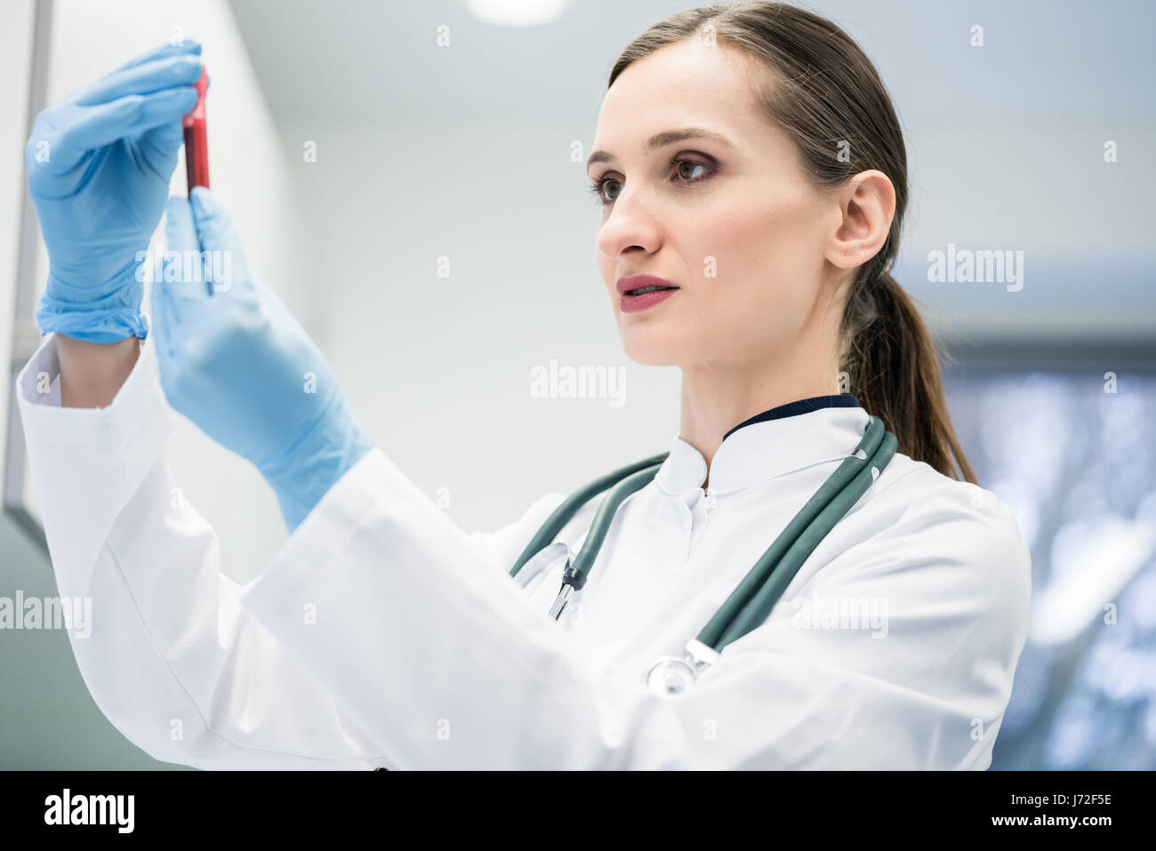 Doctor in medical laboratory looking at blood test Stock Photo - Alamy