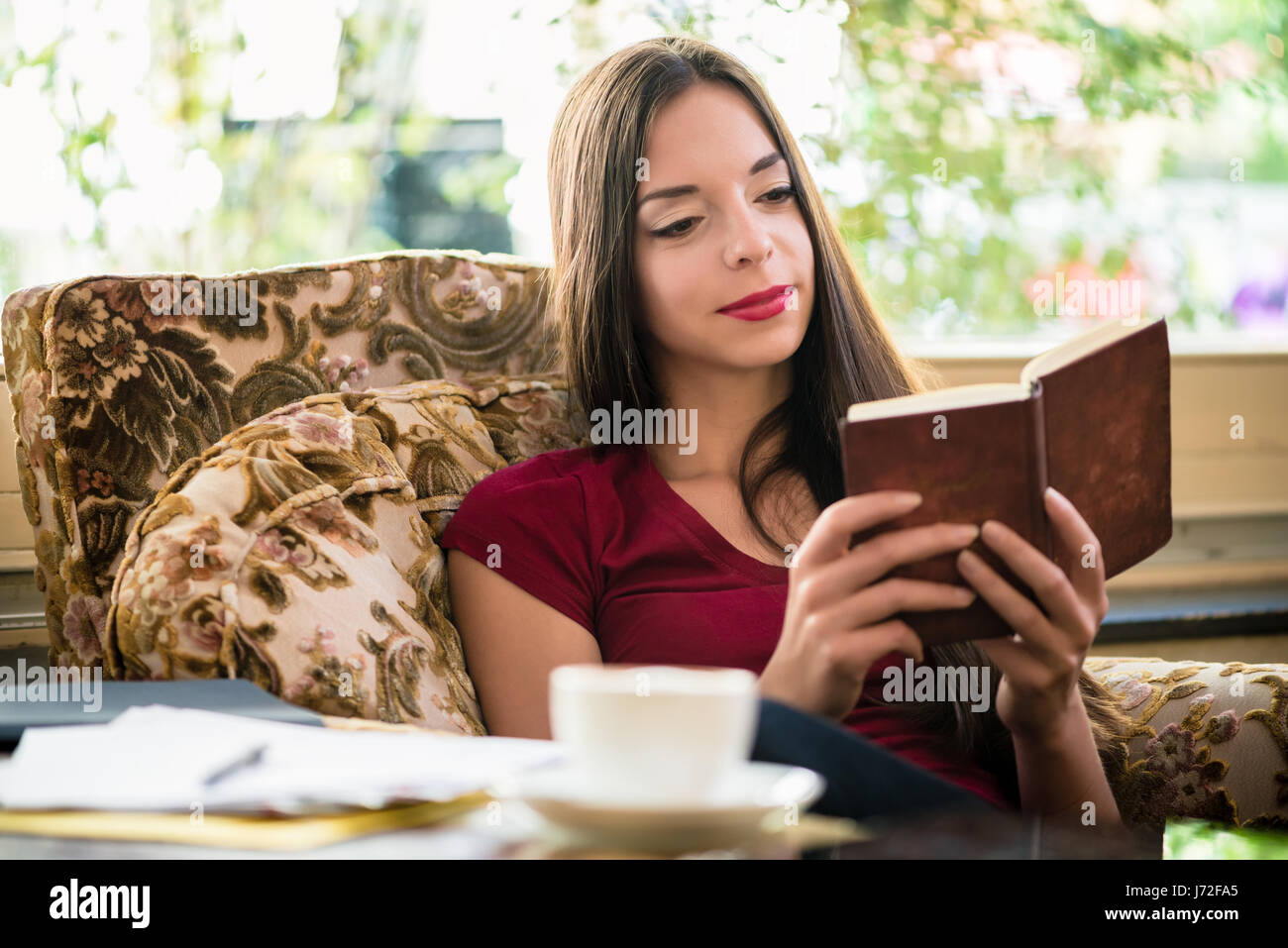 Attractive young woman reading a book Stock Photo - Alamy