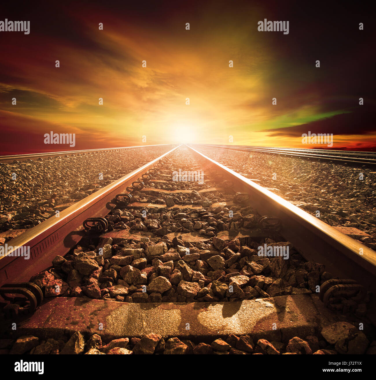 junction of railways track in trains station agains beautiful light of ...