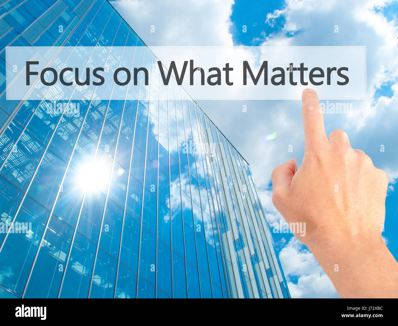 Focus on What Matters - Hand pressing a button on blurred background ...