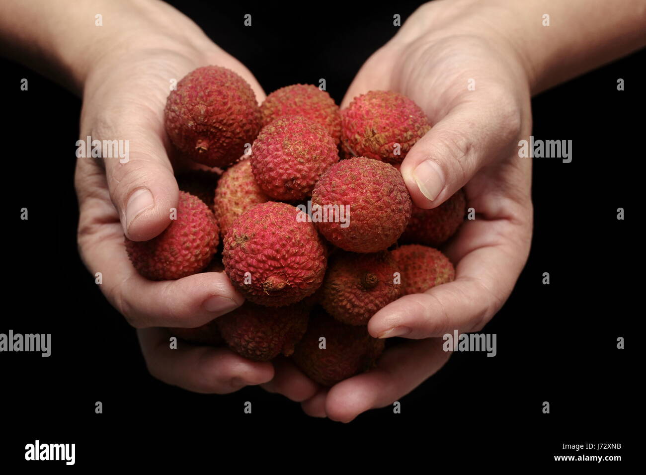 Delicious Lychee in hand on the black background Stock Photo - Alamy