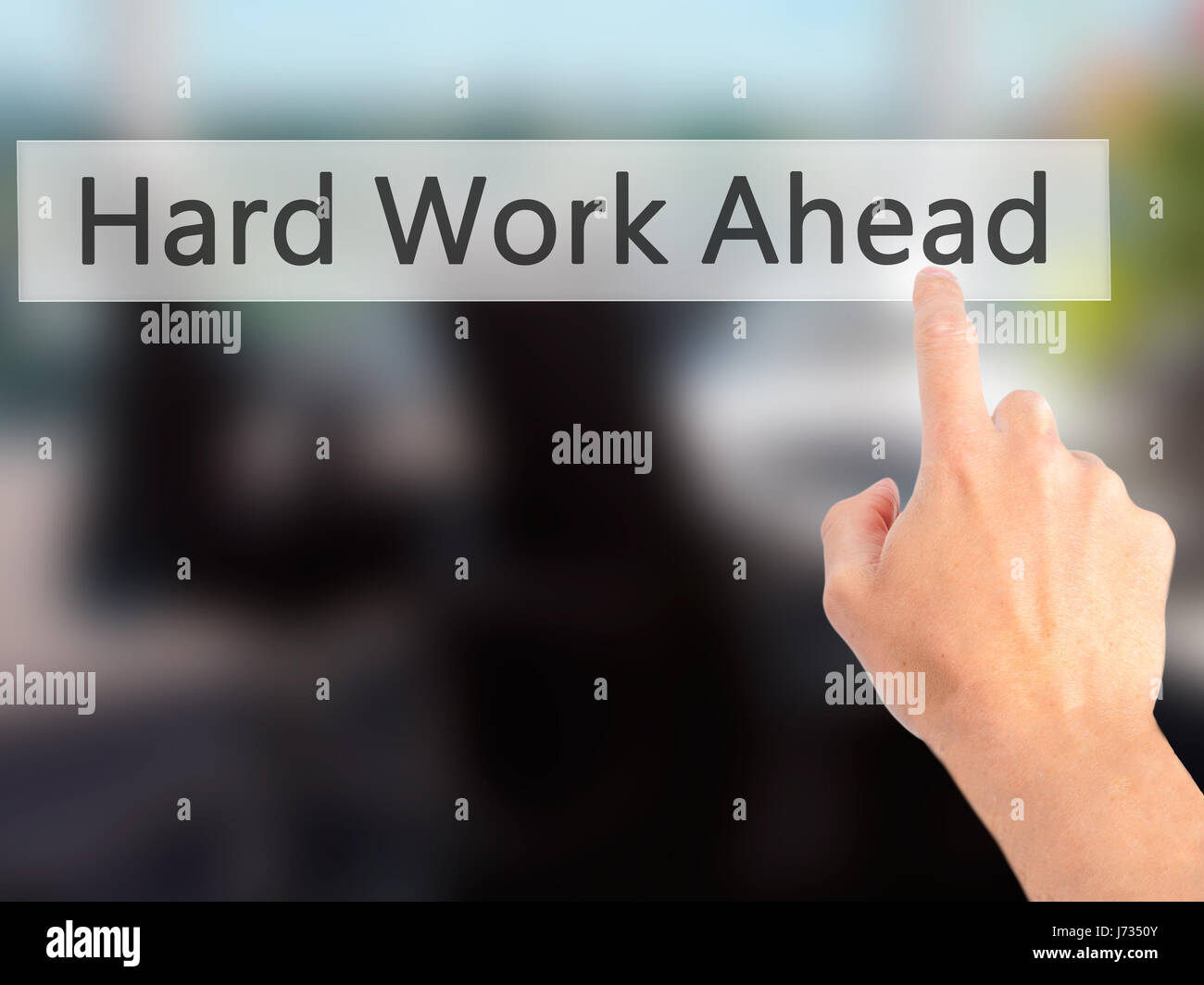 Hard Work Ahead - Hand pressing a button on blurred background concept ...