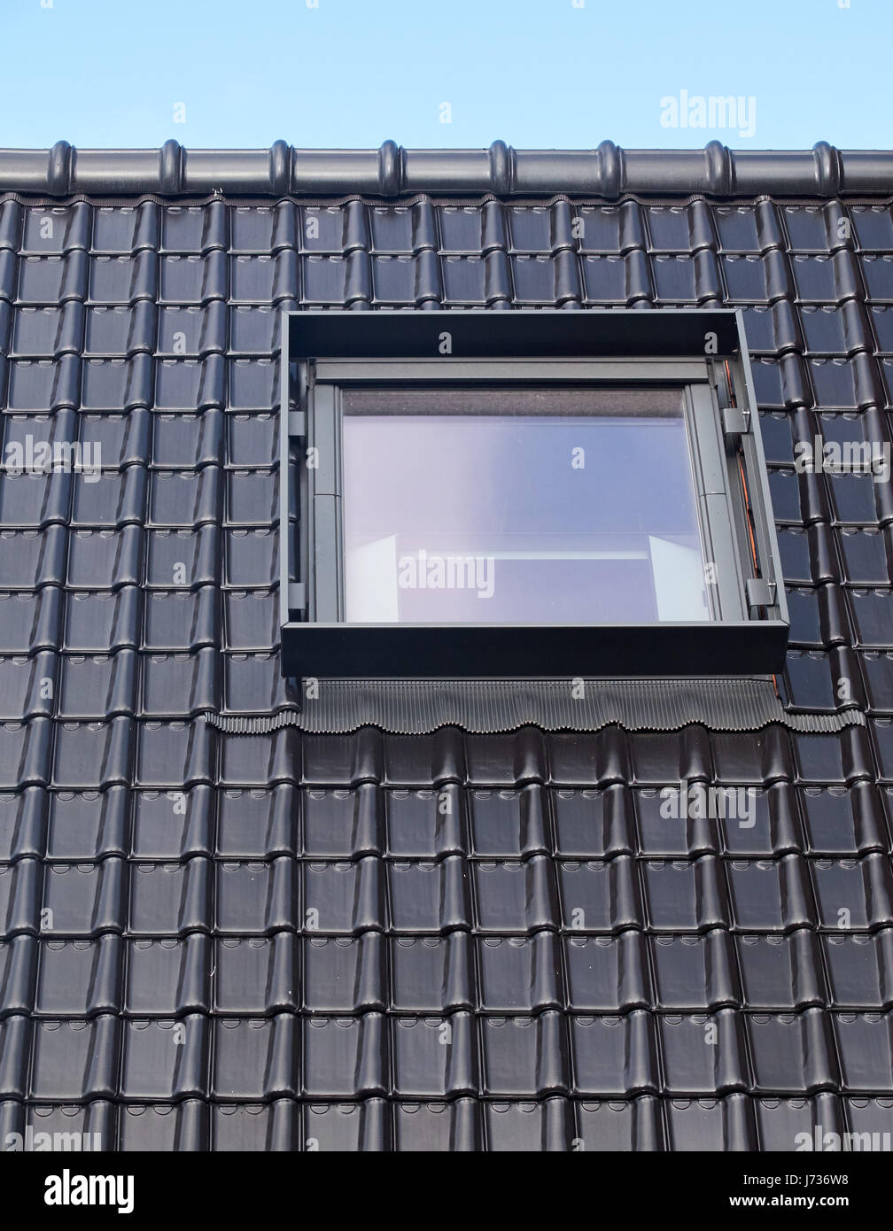 Roof with black tiles and inserted window Stock Photo - Alamy