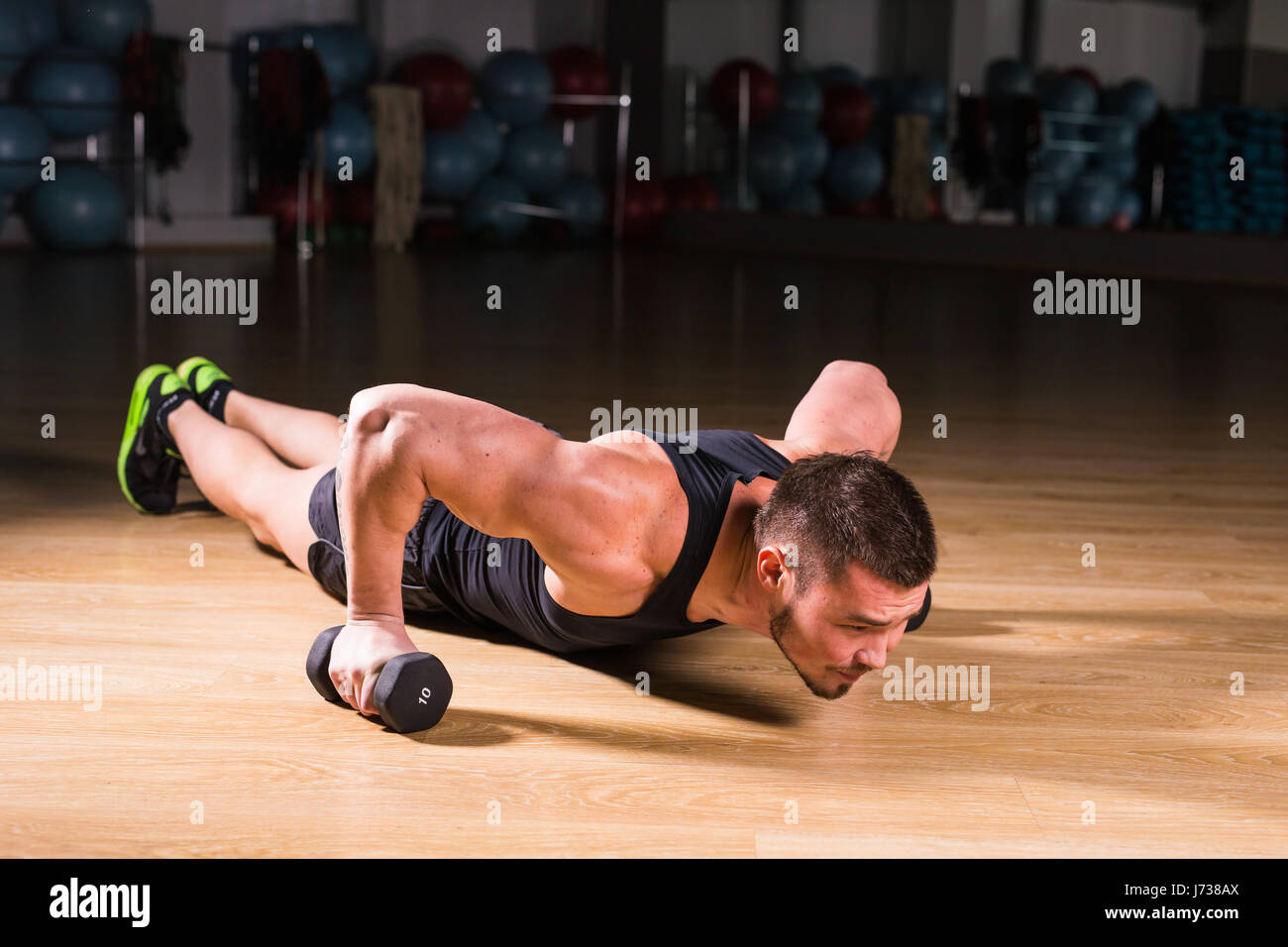 Young Man Athlete Doing Pushups With Dumbbells As Part Of Bodybuilding ...