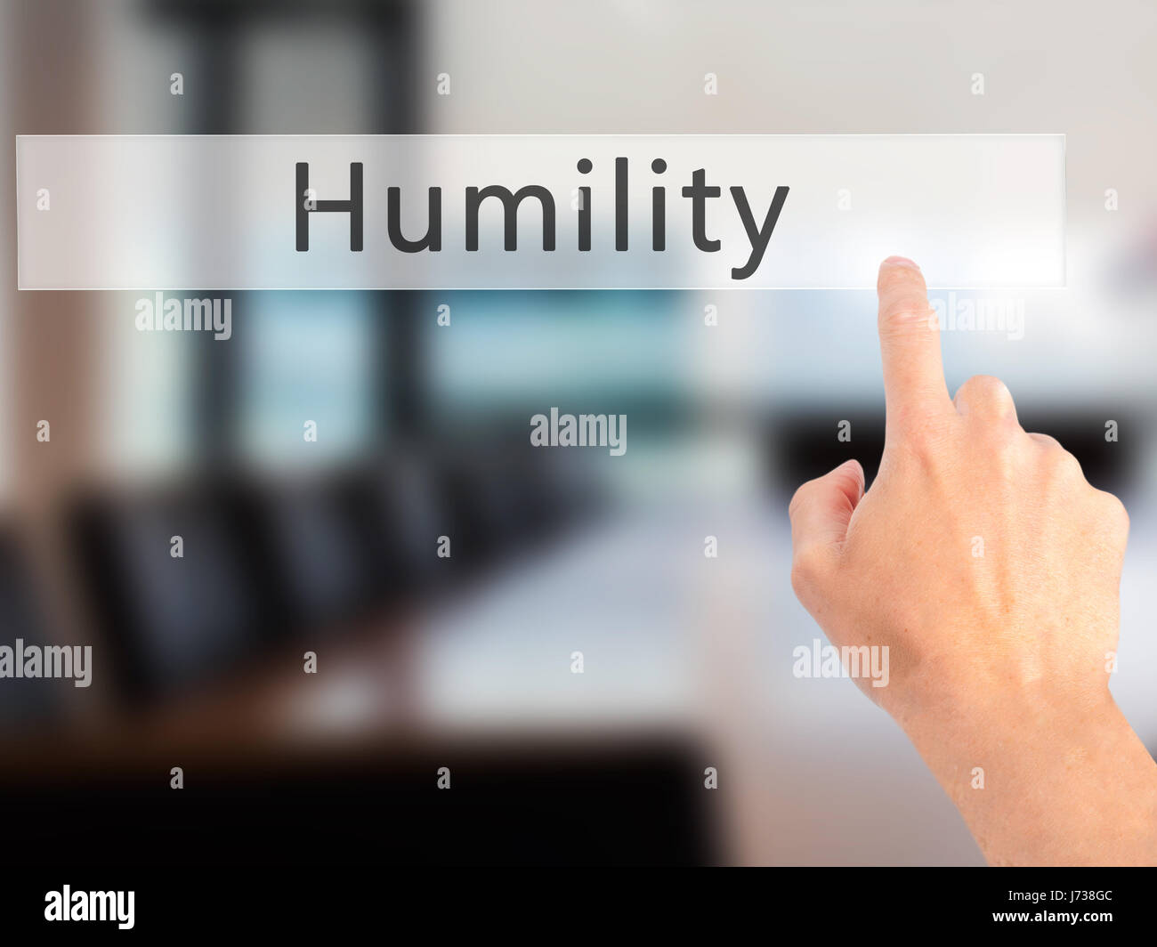 Humility - Hand pressing a button on blurred background concept ...
