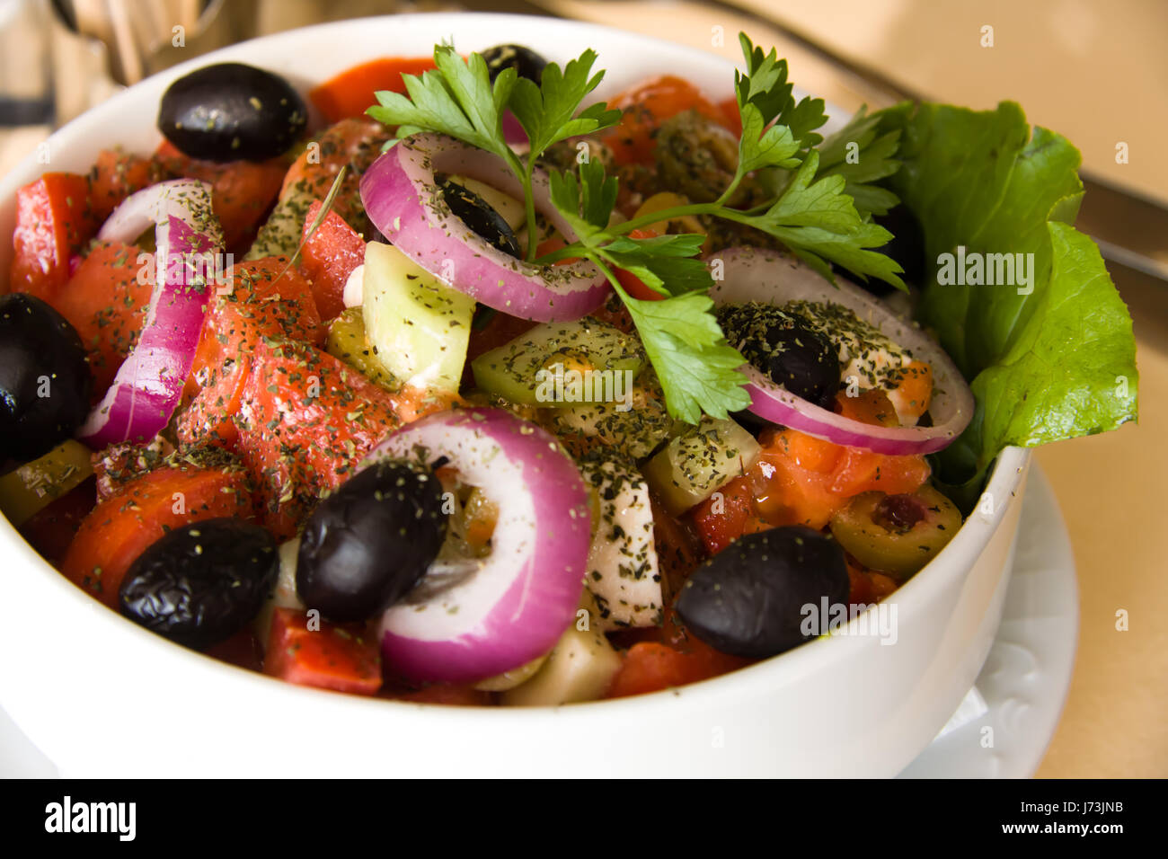 greek cucumber paprika peppers lettuce tomato salad ring closeup black ...