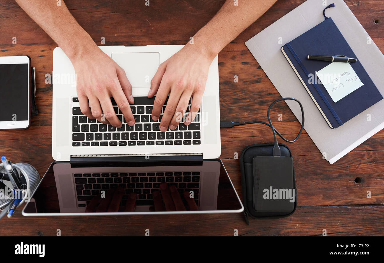 Overhead view of caucasian hands typing on a modern laptop Stock Photo ...
