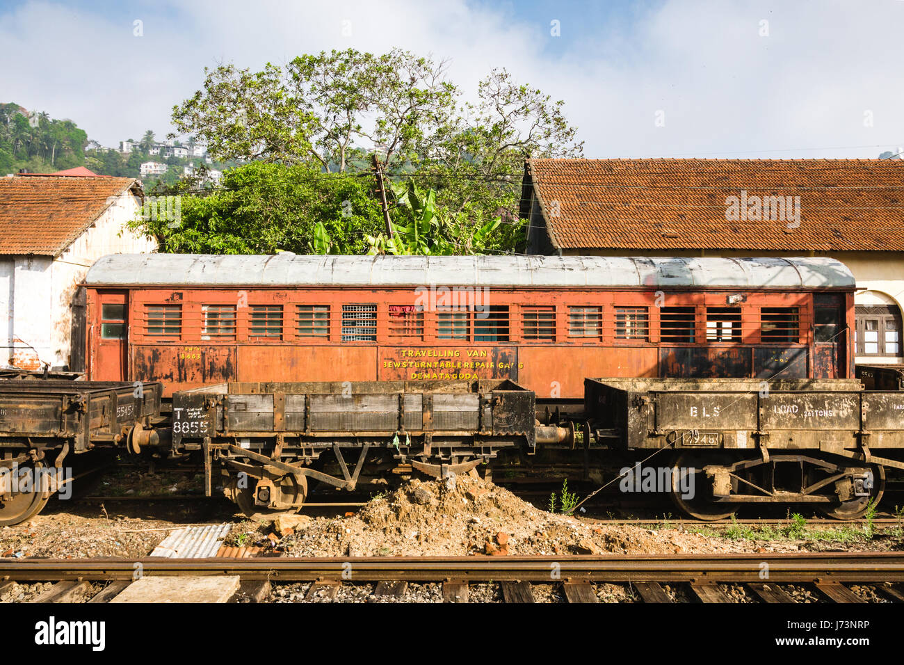 An old red train car sits abandoned in Kandy railway station, Sri Lanka ...