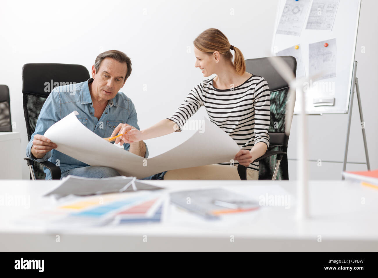 Professional engineer discussing a blueprint Stock Photo - Alamy