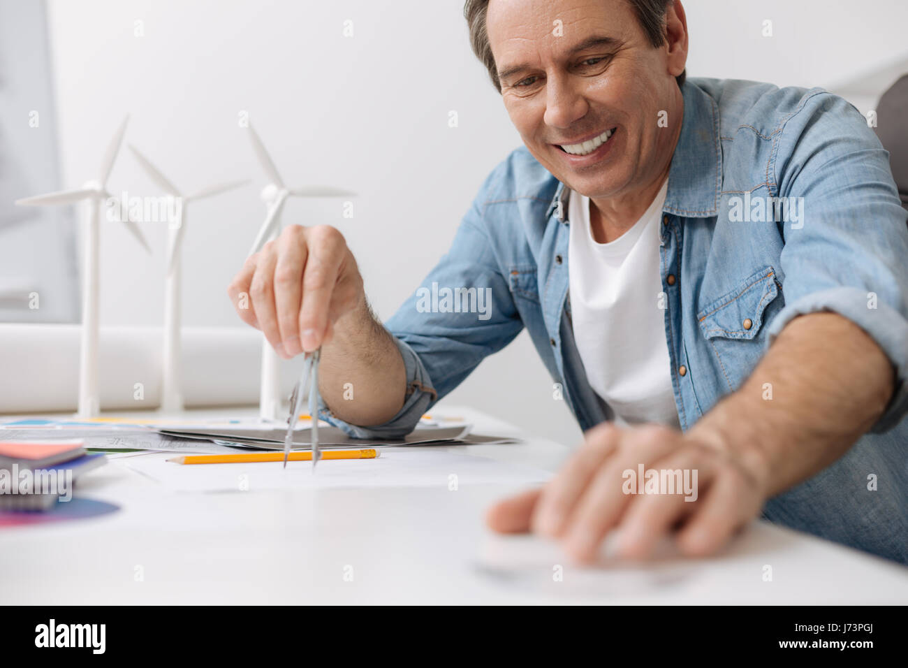 Positive engineer drawing a blueprint Stock Photo - Alamy